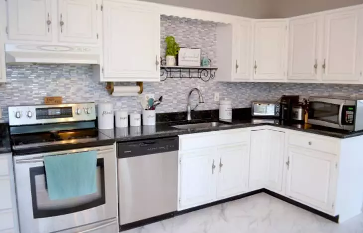 Dapur dengan backsplash tempel dalam pola mosaik abu-abu dan putih.