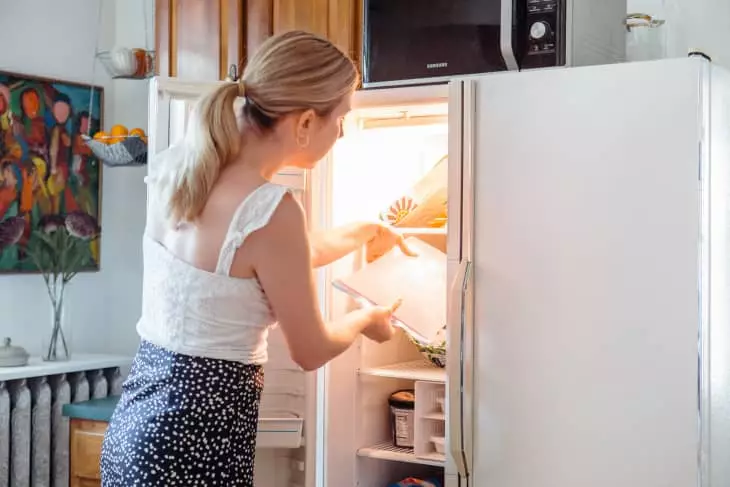 E Ziploc Sak mat gefruerene Waasser aus dem Frigo erofhuelen