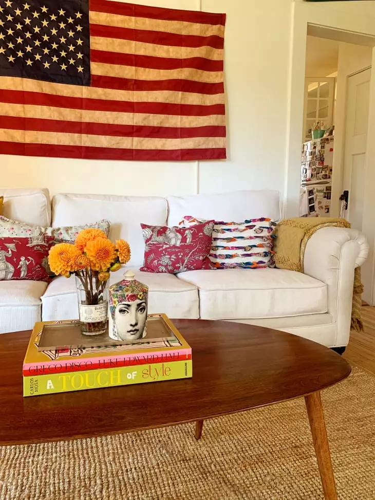 Couchtisch und weißes Sofa mit amerikanischer Flagge, die oben an der Wand hängt