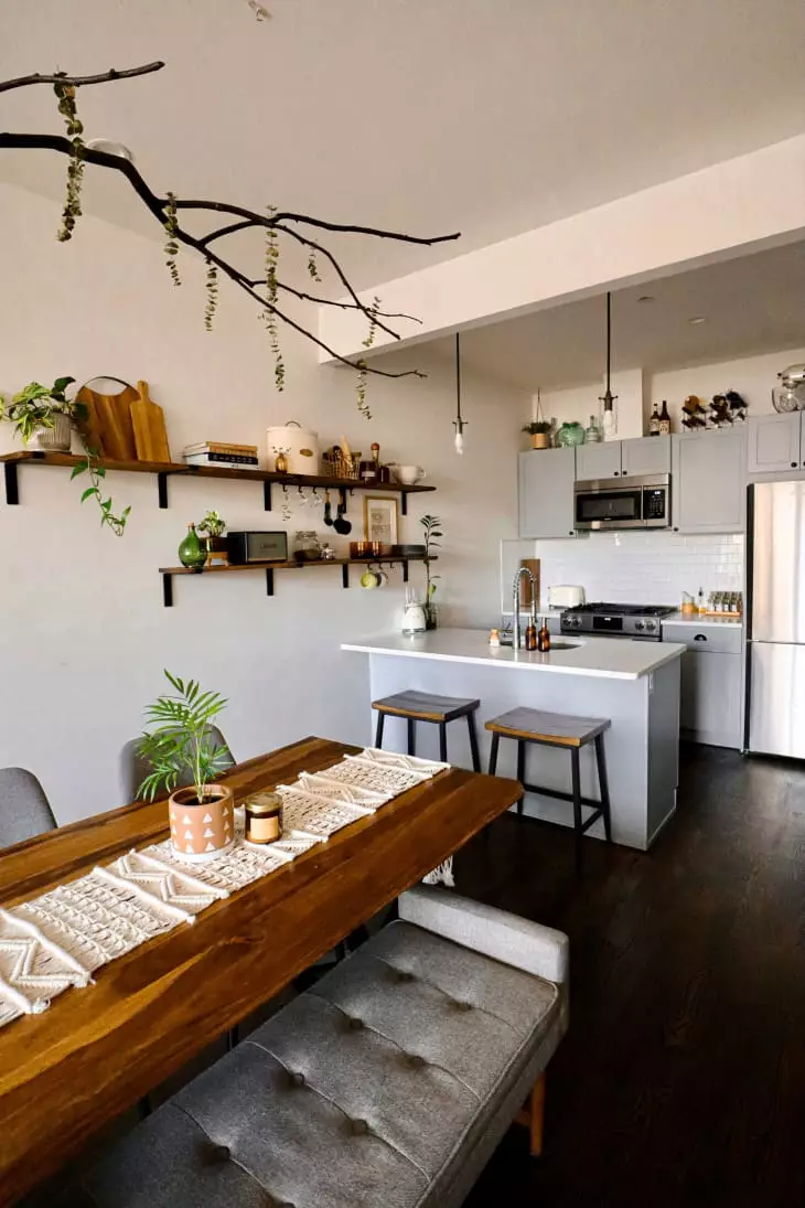 Mesa de comedor con vista de cocina en segundo plano.