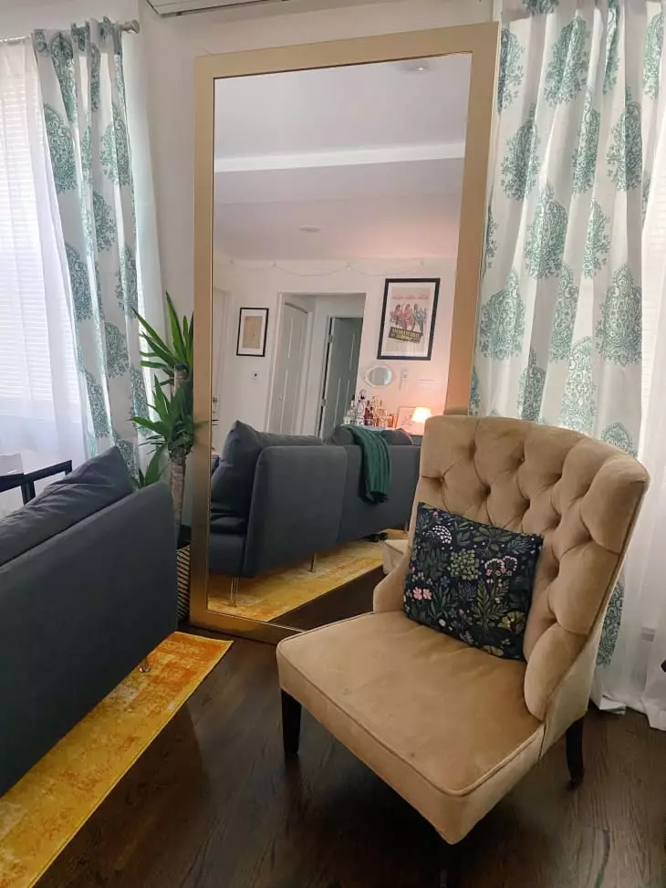 Vintage tuftad stol bredvid spegeln i vardagsrummet
