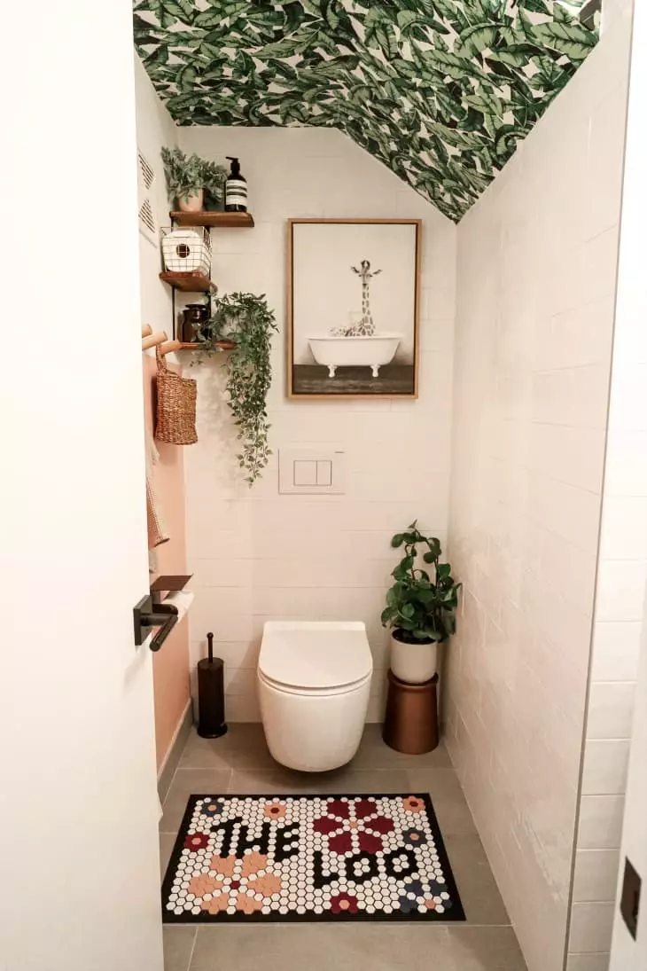 Banheiro com papel de parede de folha verde no teto