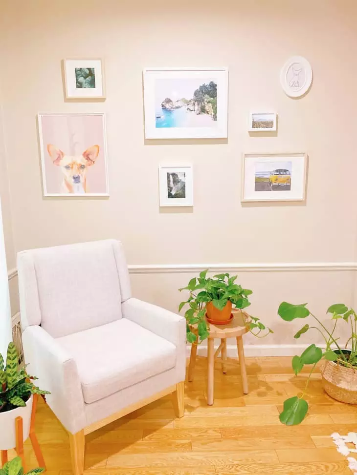 Plantas y una silla blanca estilo mediados de siglo en una esquina debajo de la pared de la galería