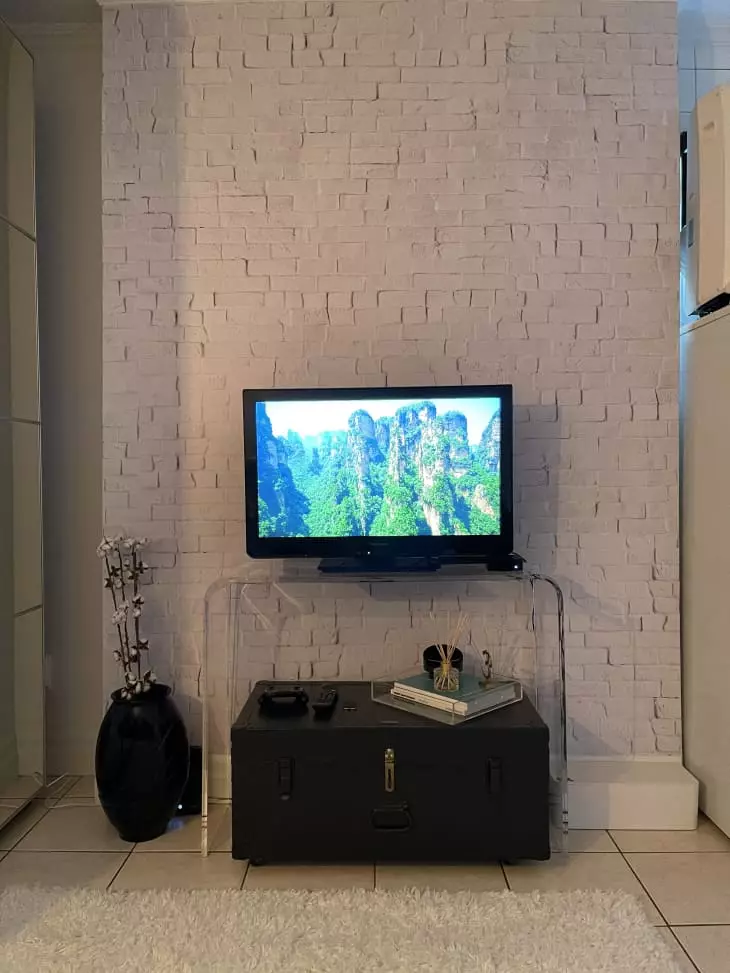 TV trên bàn điều khiển acrylic với thân cây cũ bên dưới