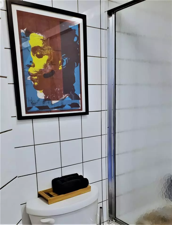 चौकोर टाइल वाली दीवारों के साथ बाथरूम में राजकुमार की कलाकृति