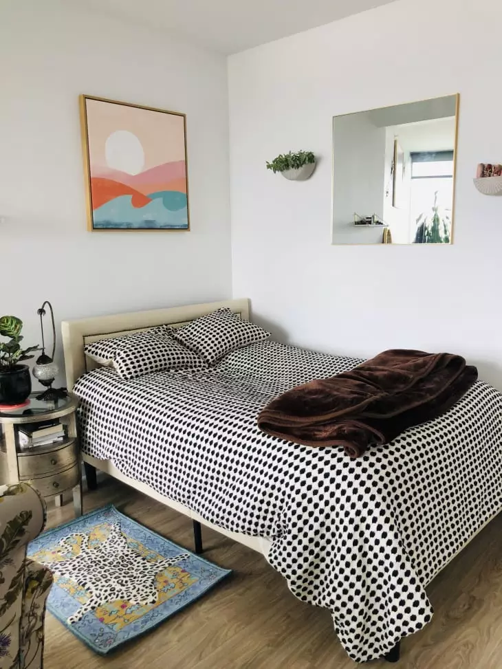 Tempat tidur dengan seprai bertitik di sudut apartemen