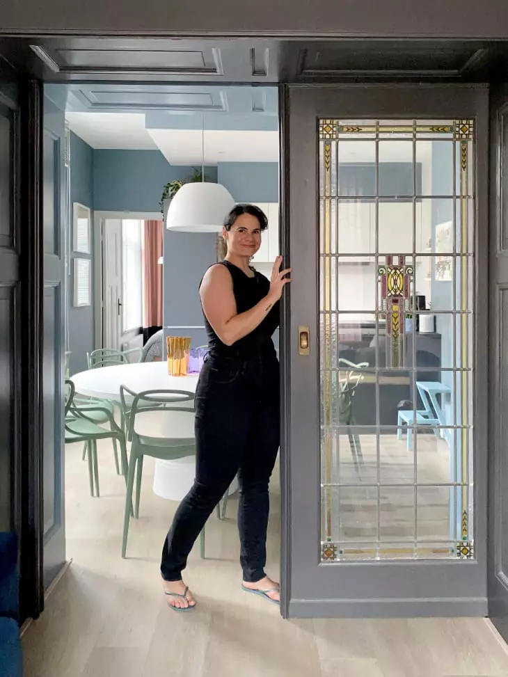 Kvinna som står bredvid franska dörrar som leder in i matsalen