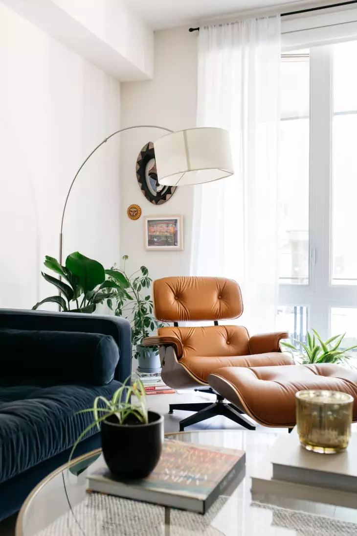 Obývacia izba s modrou zamatovou pohovkou a koňakovým kreslom Eames