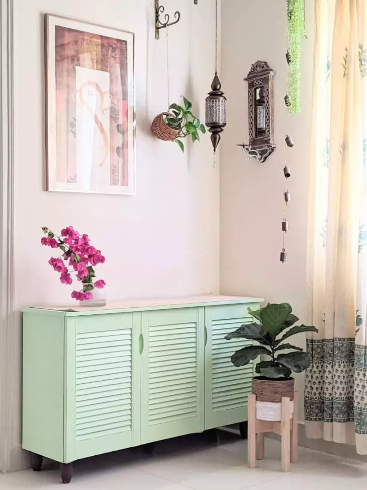 Credenza hijau mint di sudut ruangan dengan dinding pink muda