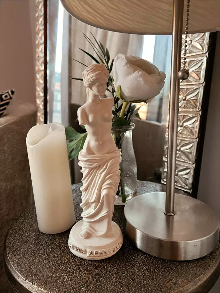 Afrodite-skulptur ved siden af lampe på endebord