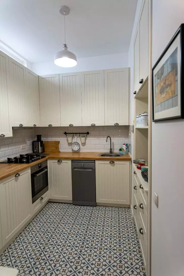 Փոքր խոհանոց՝ սպիտակ գույնի պահարաններով, կախազարդ լույսով և սալիկապատ հատակով