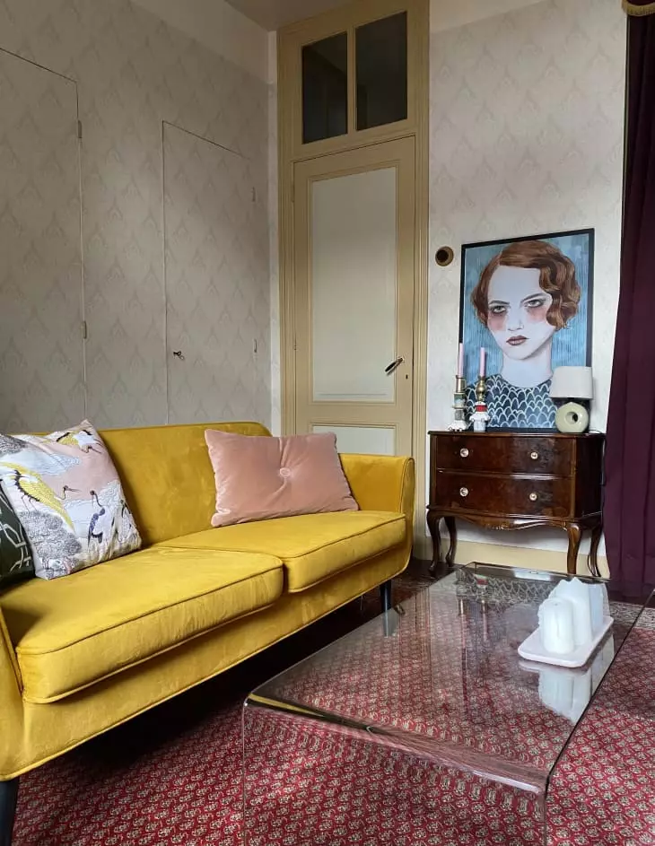 Stue med gul sofa og klart salongbord i akryl