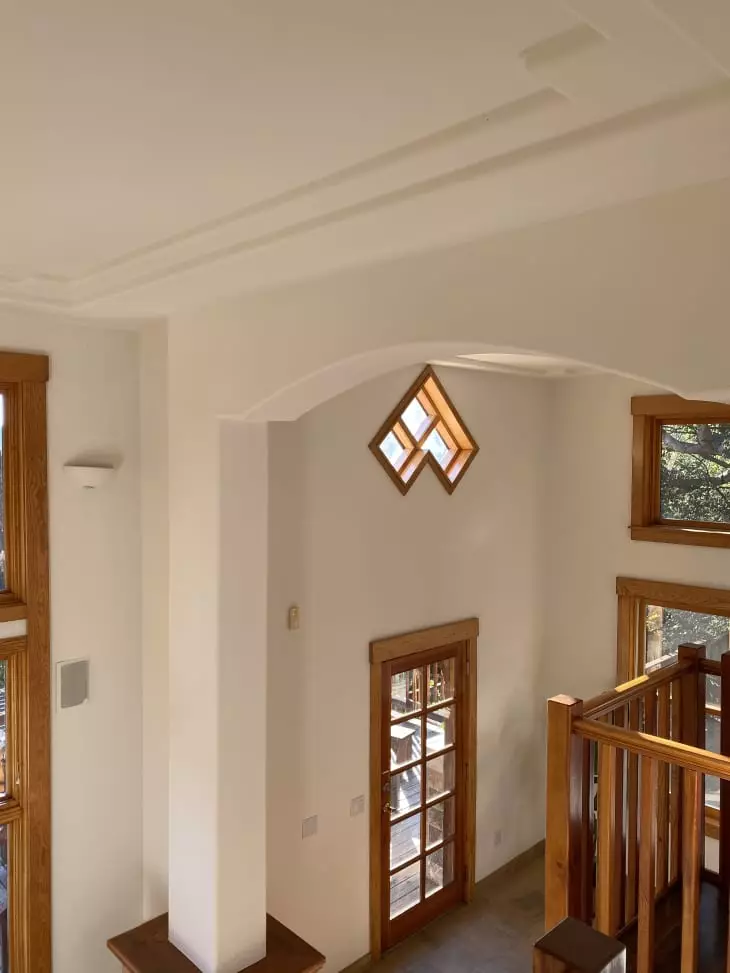 Porte d'entrée de la maison avec de nombreuses fenêtres en bois