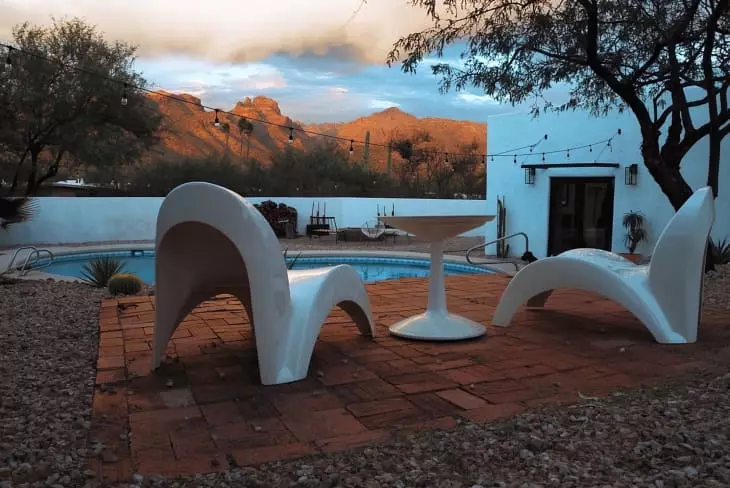 수영장 옆에 있는 현대적인 라운지 의자와 테이블