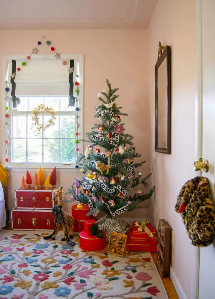Božićno drvce u kutu sobe s cvjetnim tepihom