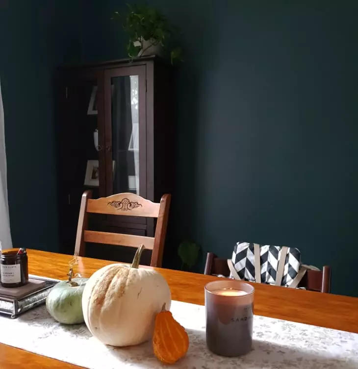 Taula de menjador a l'habitació amb parets de color verd fosc