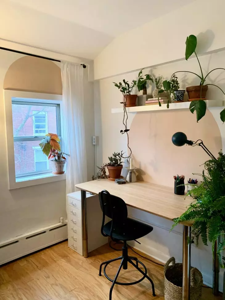 Escritorio rodeado de plantas no cuarto de hóspedes