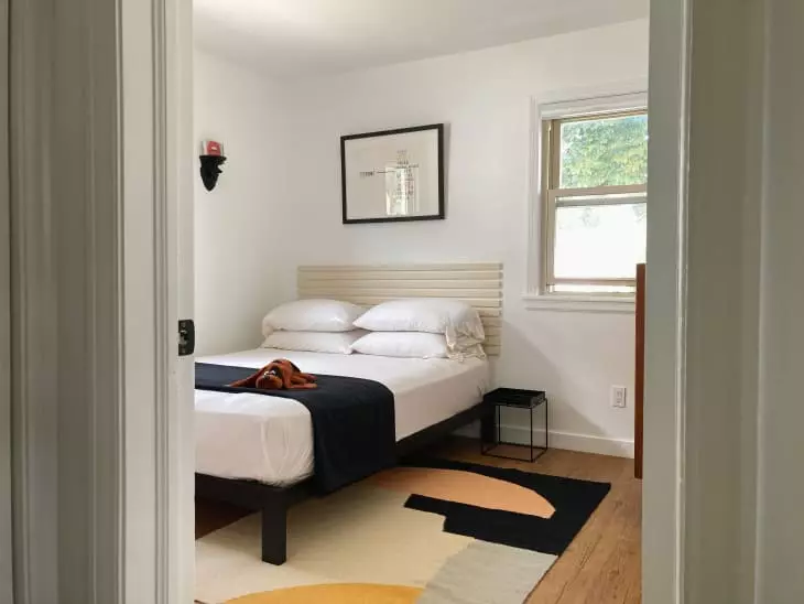 Vista del dormitorio blanco y negro a través del marco de la puerta