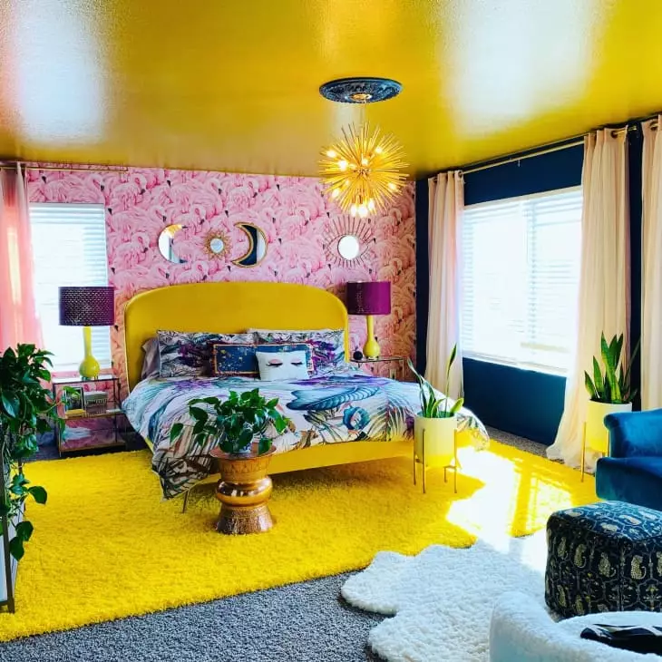 노란색 깔개, 노란색 침대, 노란색 천장, 분홍색 플라밍고 벽지가 있는 침실