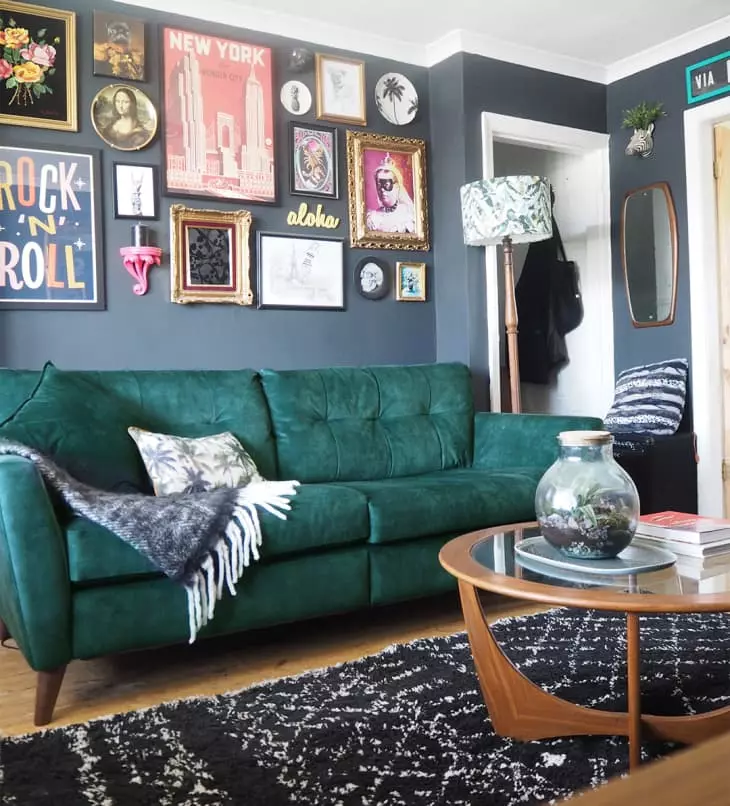 Grønn sofa med gallerivegg av innrammet kunstverk over seg