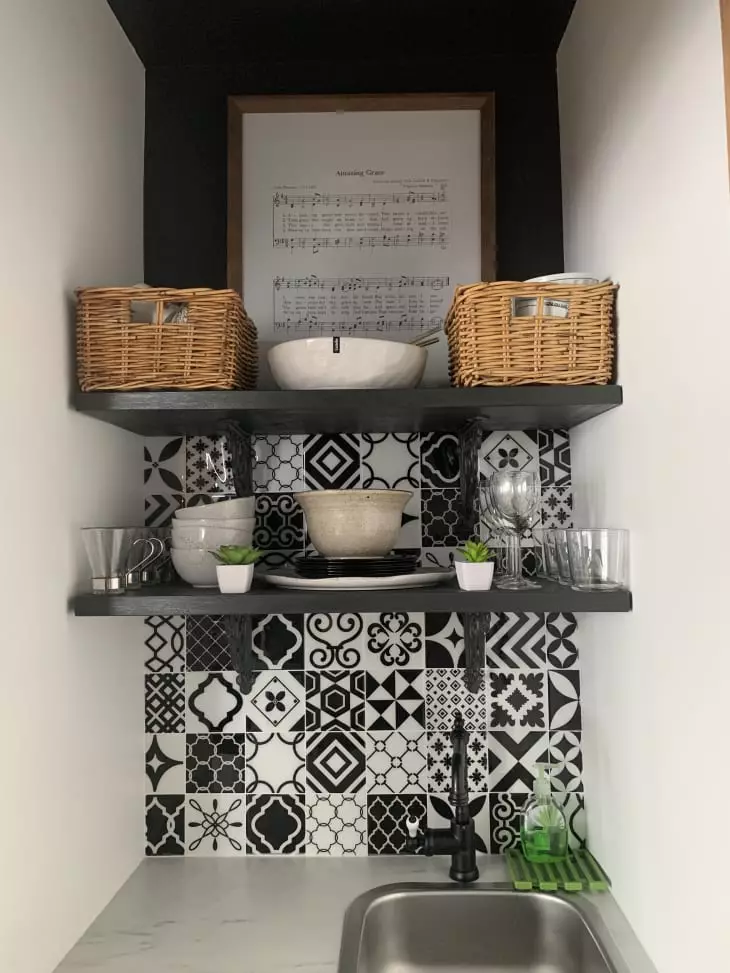 Półki i czarno-biała płytka nad małą umywalką