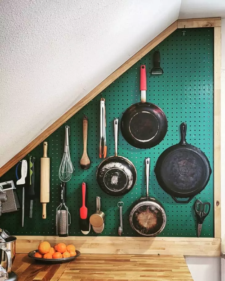 pegboard héjo dina témbok leutik ngeusi Panci sarta parabot masak