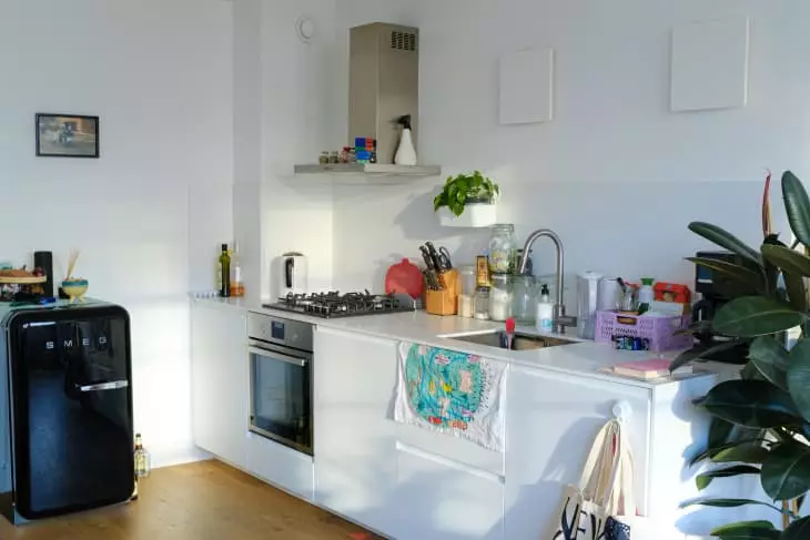 Meestal witte keuken met kleurrijke accenten en zwarte mini Smeg koelkast