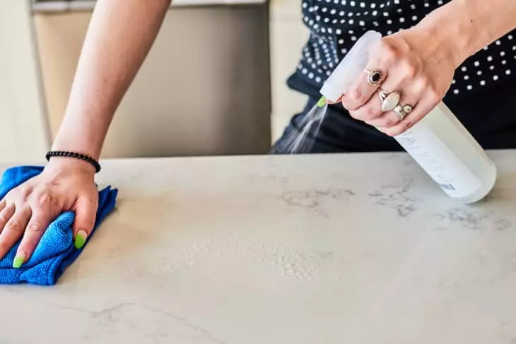 froulju spuiten skjinner op keuken oanrjocht