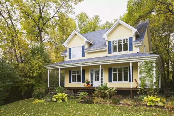 Gele dakspaan met blauwe en witte gevel in cottage-stijl in de herfst, Quebec, Canada.