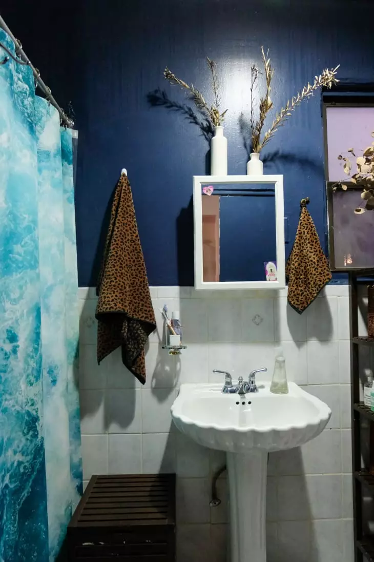 Kamar mandi dengan dinding biru dan tirai shower