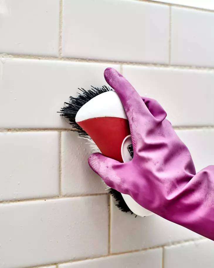 Scrubbing iwe Odi pẹlu kan lile fẹlẹ wọ satelaiti ibọwọ