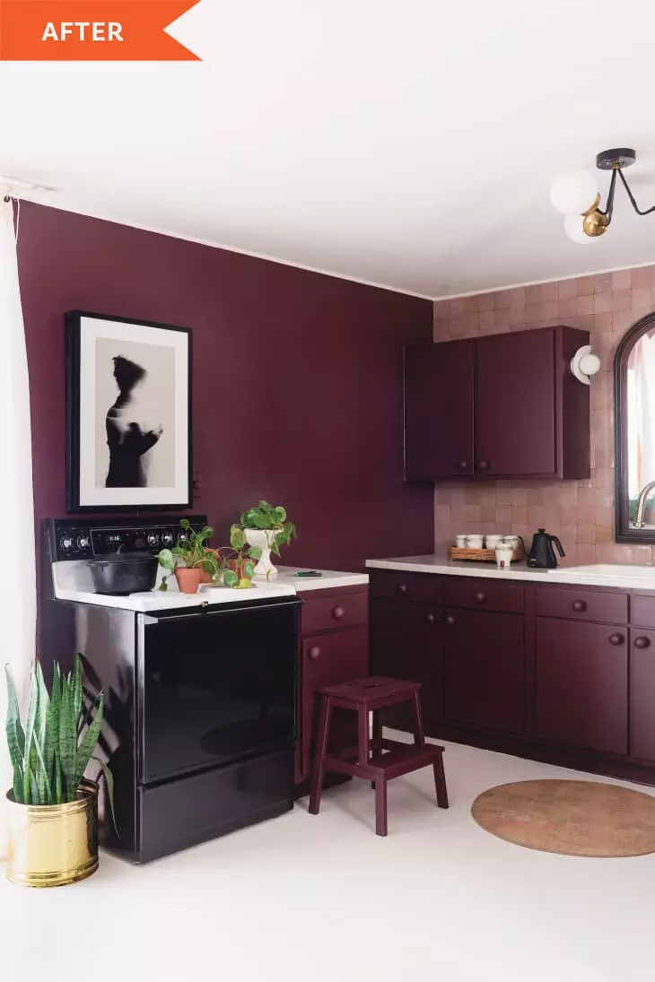 厨房一角，梅洛墙上挂着艺术品，黑色烤箱