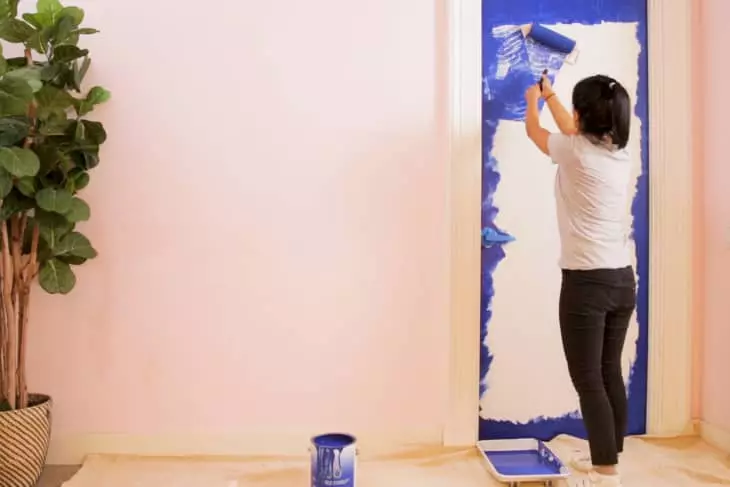 Žena stavlja plavu boju na bijela vrata