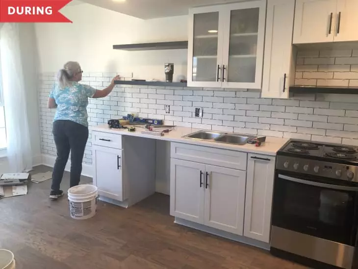 Pendant : Femme ajoutant des carreaux blancs au dosseret